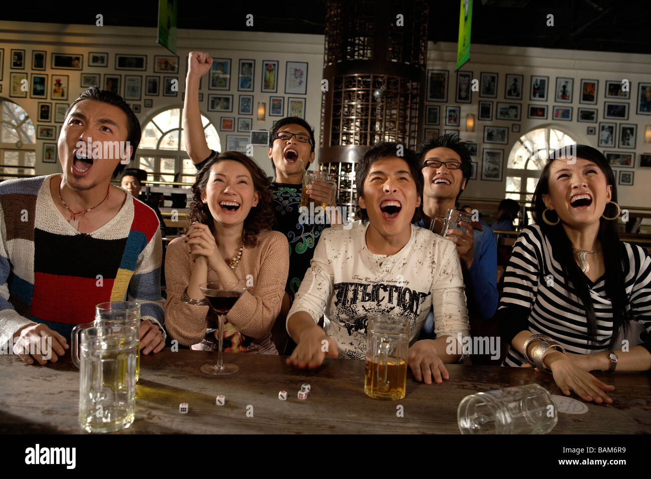 Happy Young People Watching Game In Sports Bar Stock Photo - Alamy