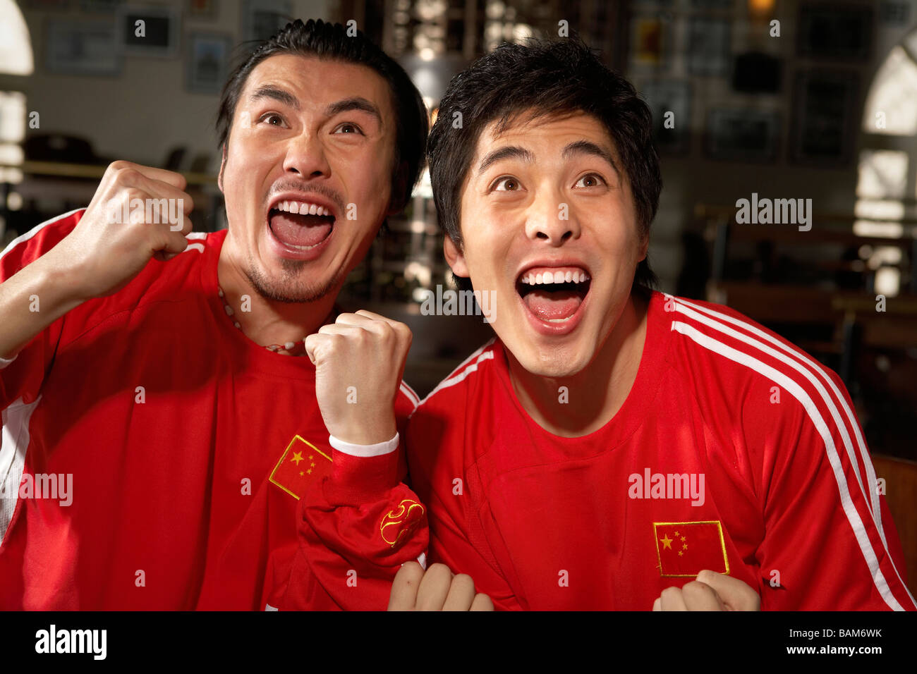Happy Sports Enthusiasts Watching Game In Bar Stock Photo - Alamy