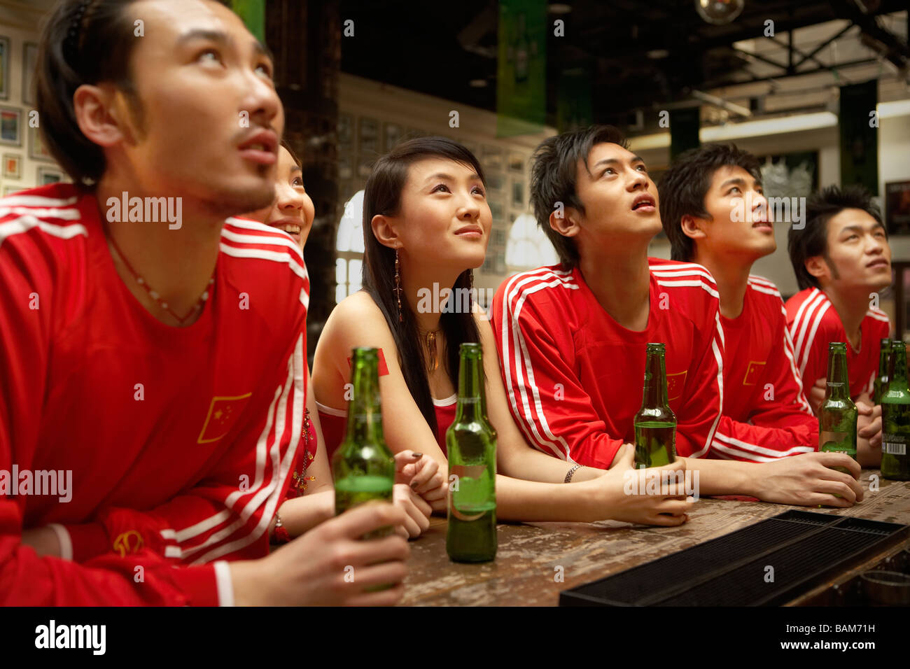 Young People Leaning On Bar Watching Game Stock Photo - Alamy
