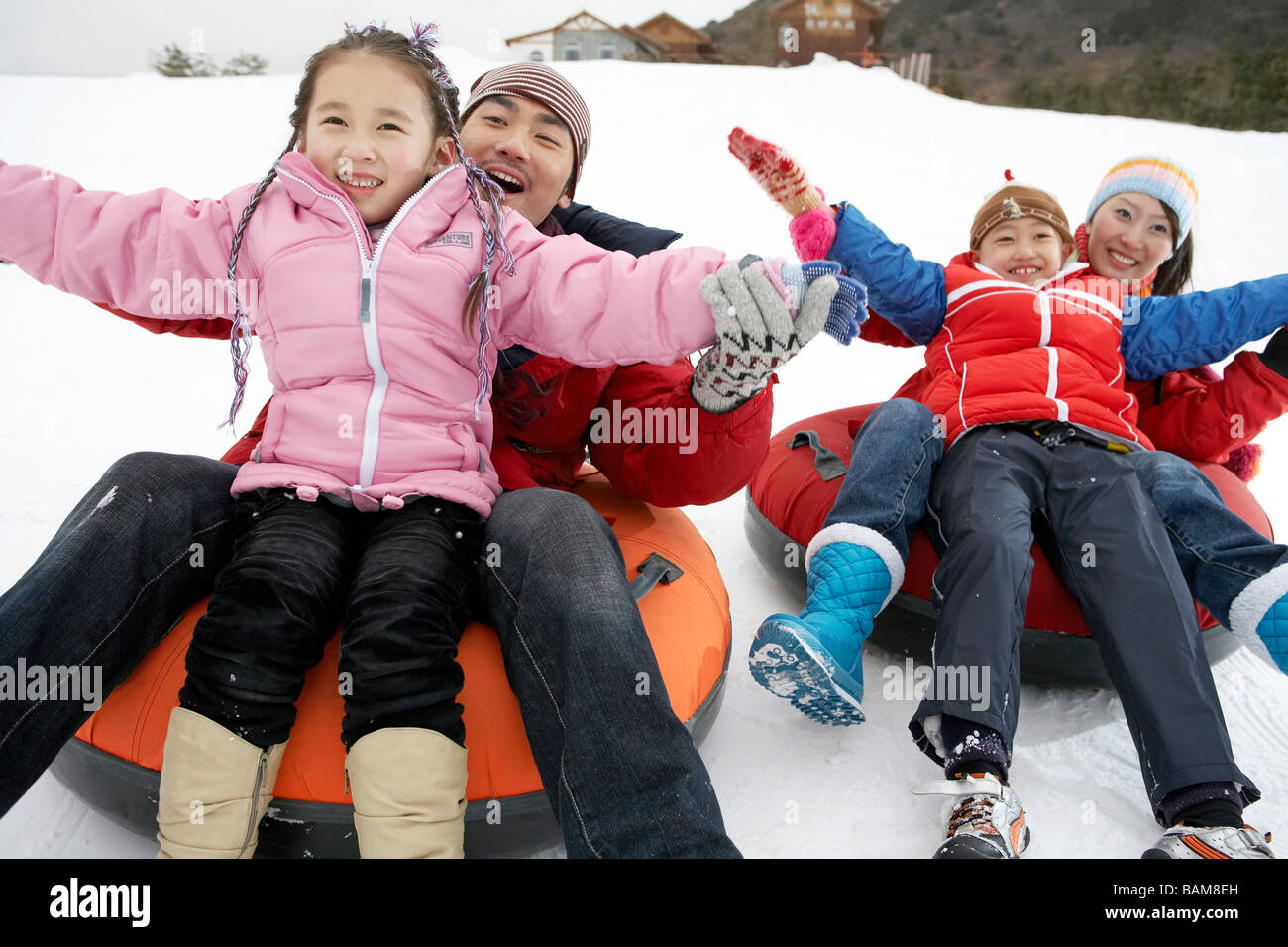 Parents And Children Riding On Inflatable Snow Tube Stock Photo - Alamy