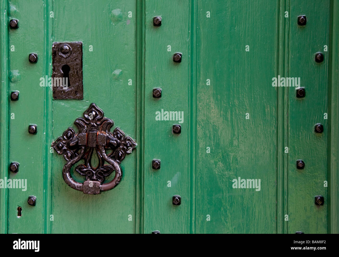 Door handle and key hole in green studded door Stock Photo - Alamy