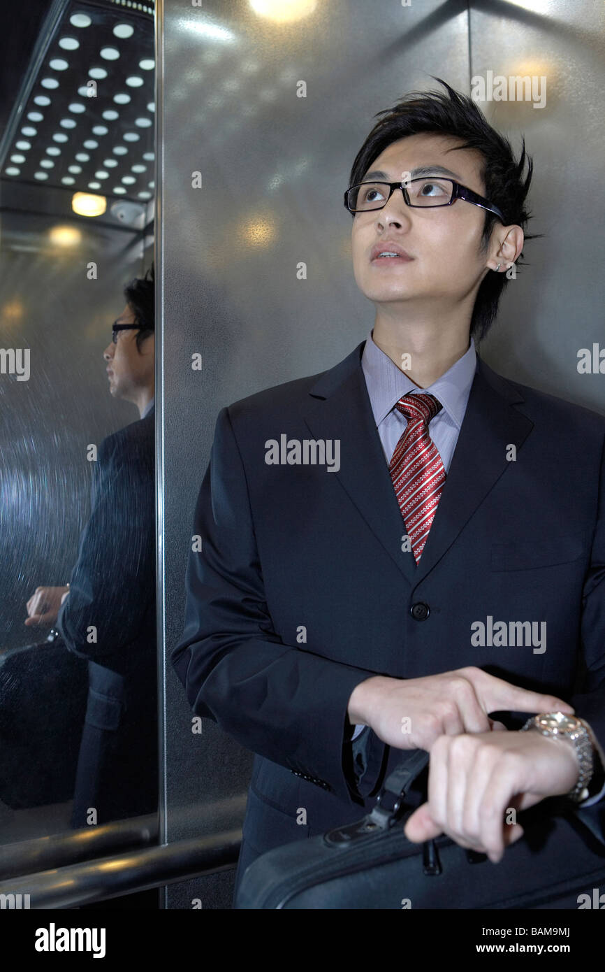 Man Looking At Watch In Elevator Stock Photo - Alamy