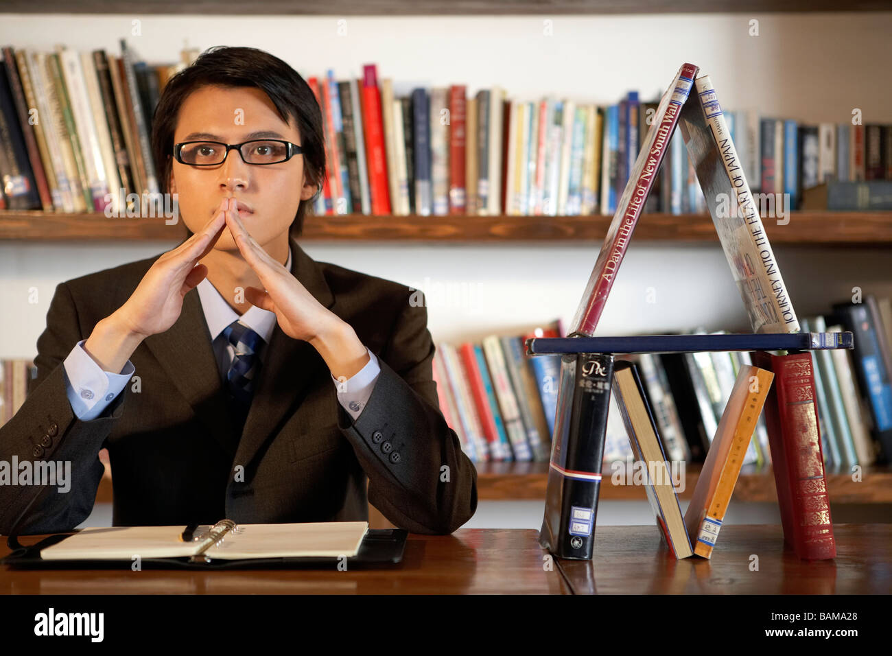 Young Man Looking Contemplative With A Small House Of Books Stock Photo ...