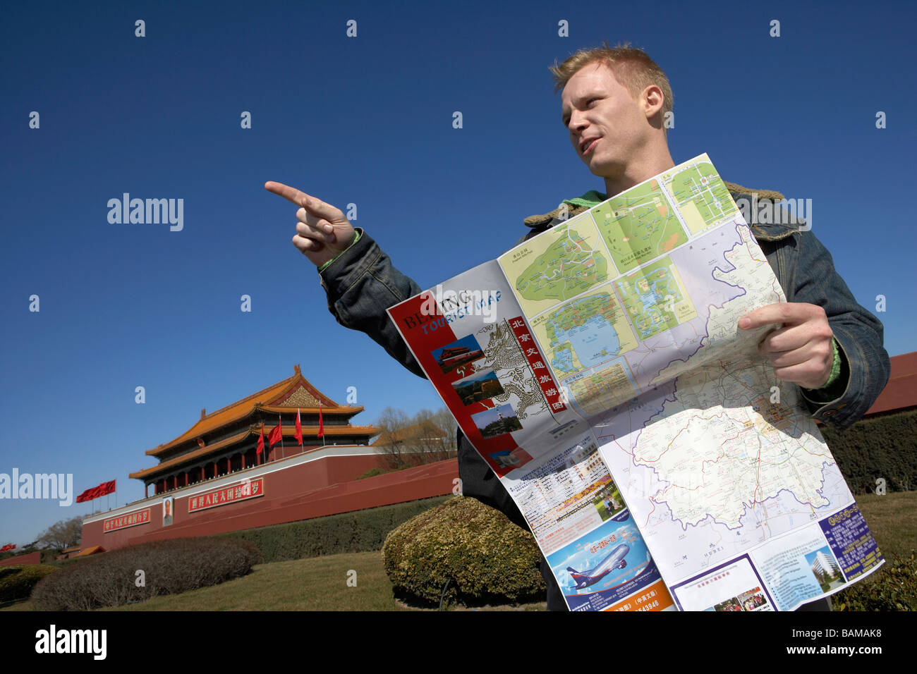 Young Man Using Map And Pointing In The Right Direction Stock Photo - Alamy