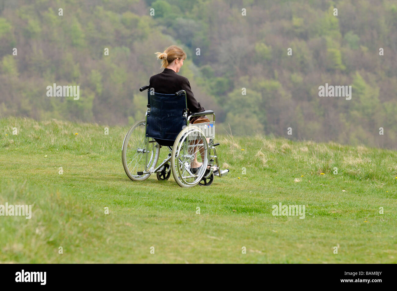 Woman wheelchair user seated overlooking some English countryside UK ...