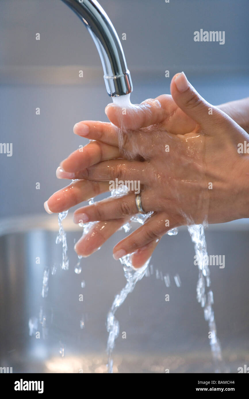 Woman is washing hands under a tap Stock Photo - Alamy