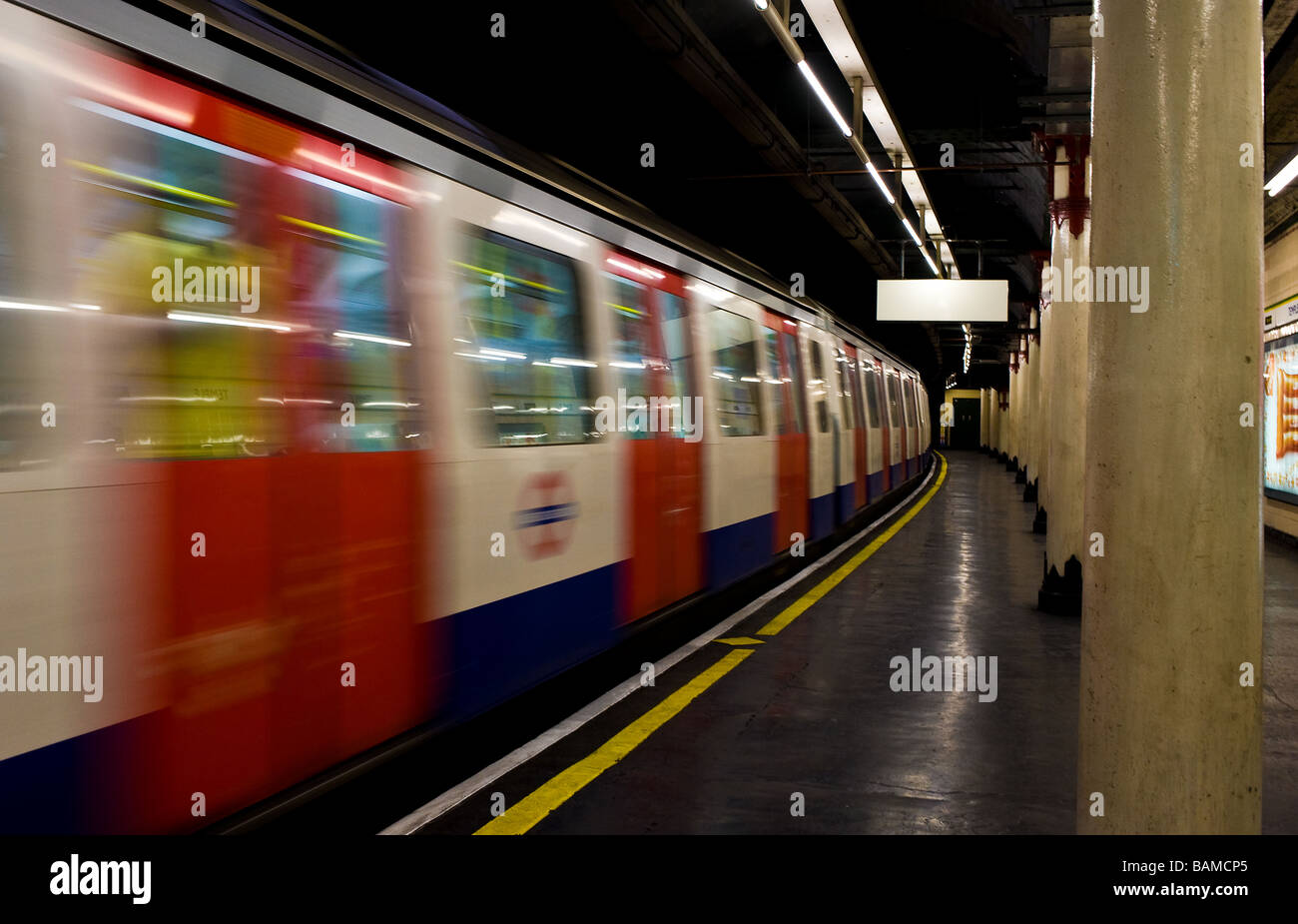 A tube train speeding into a station in London Stock Photo - Alamy