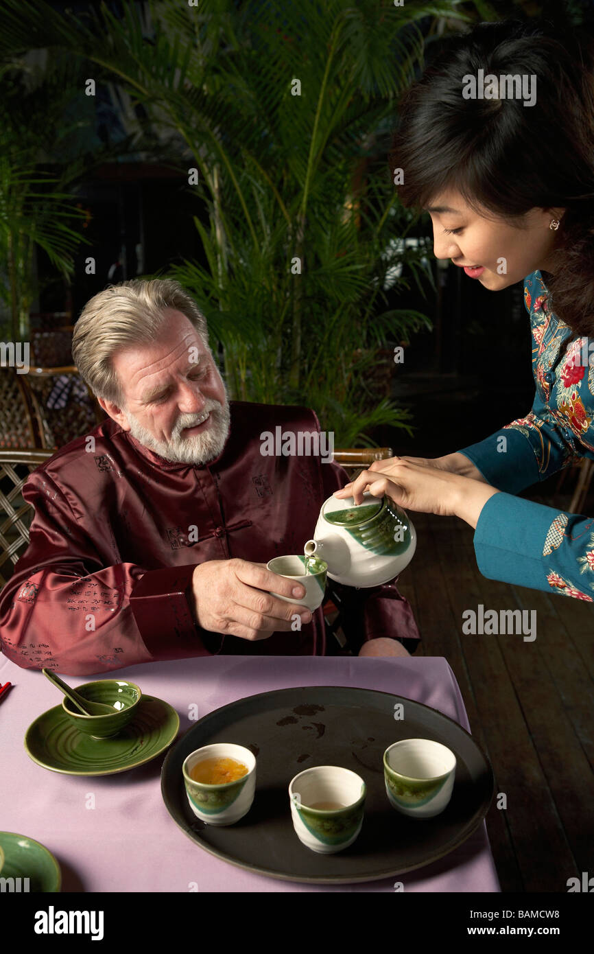 Waitress Pouring Tea For Customer Stock Photo - Alamy
