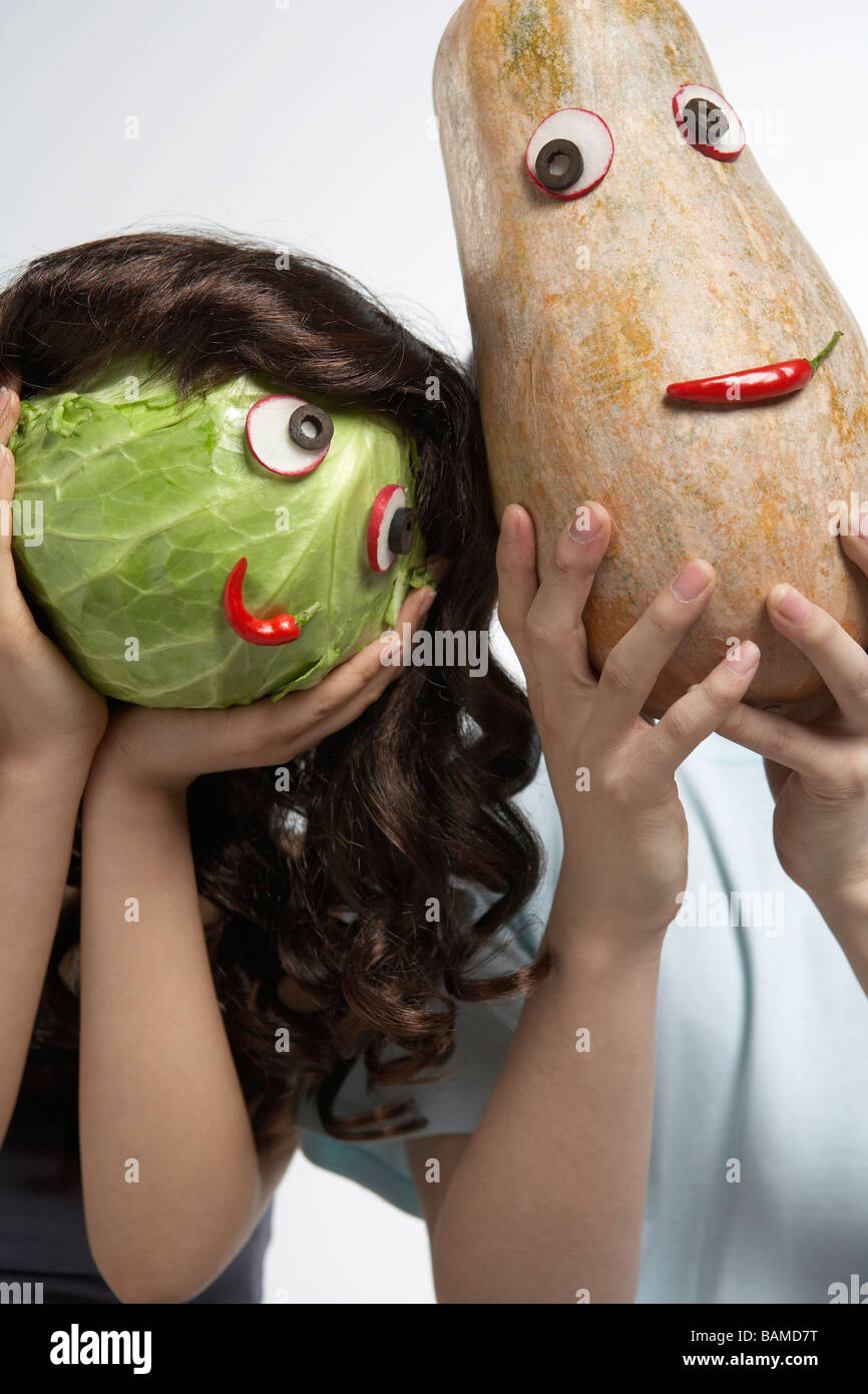 Two People Covering Their Faces With Masks Made Of Vegetables Stock ...