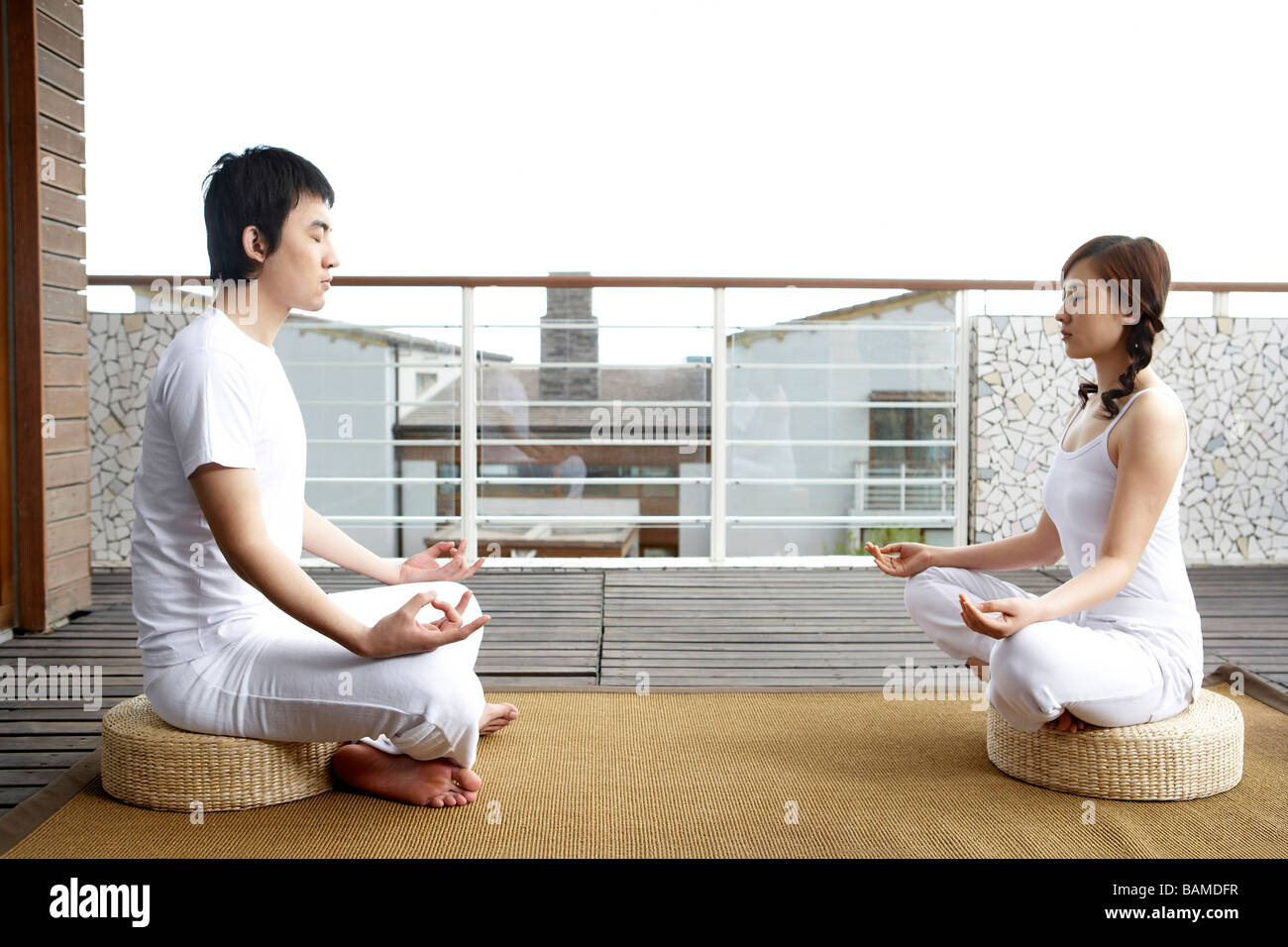 Couple Meditating On Deck Stock Photo - Alamy