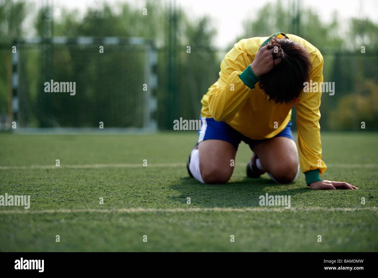 Disappointed Soccer Player On His Knees Stock Photo - Alamy