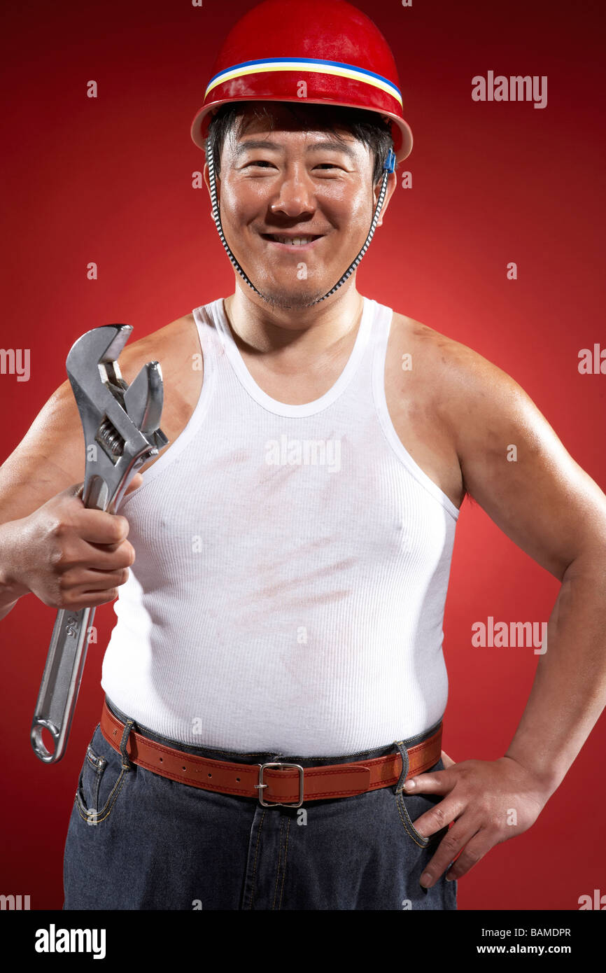 Man Wearing A Hard Hat Holding A Spanner Stock Photo - Alamy