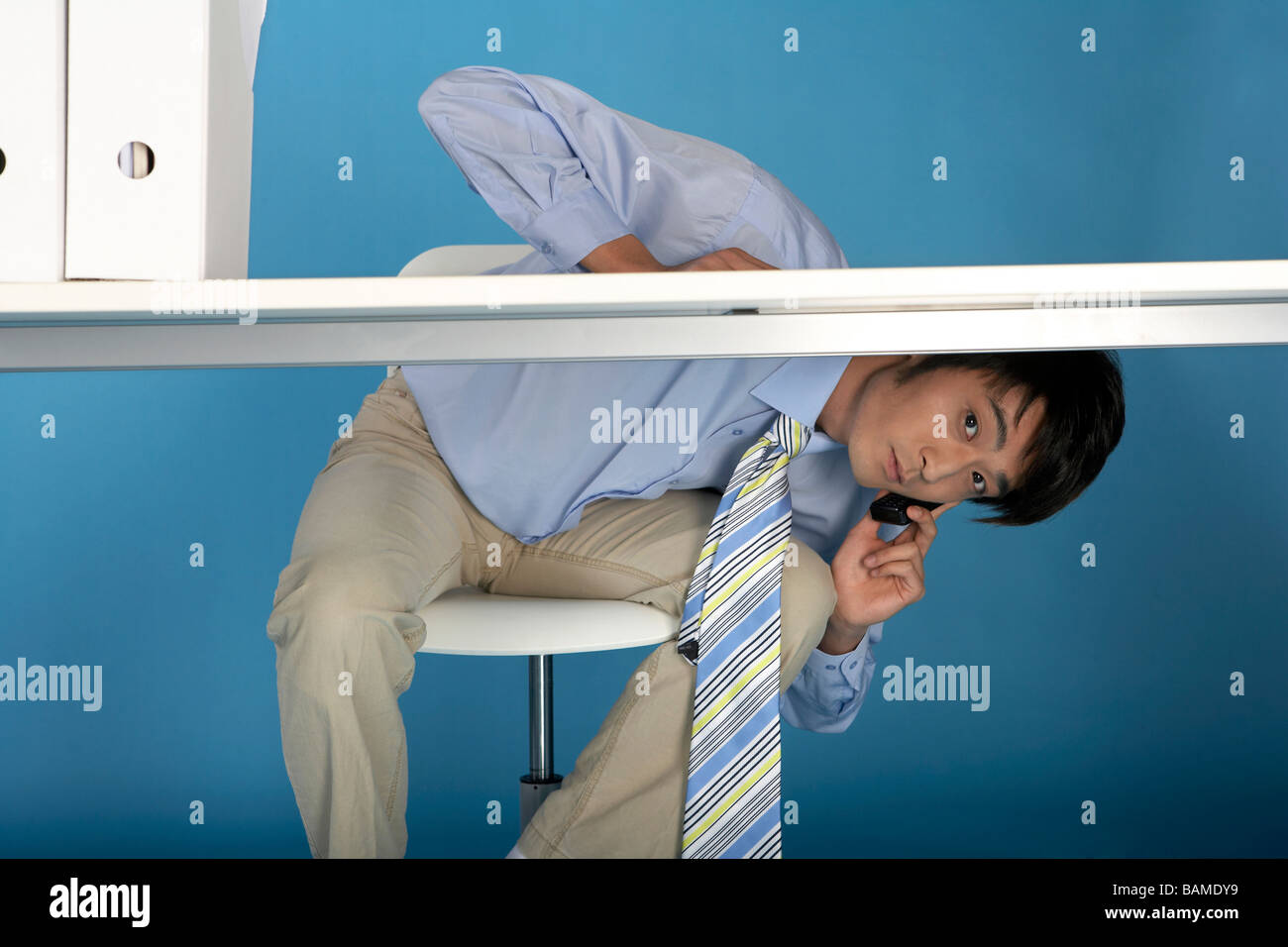 Person hiding under desk hi-res stock photography and images - Alamy