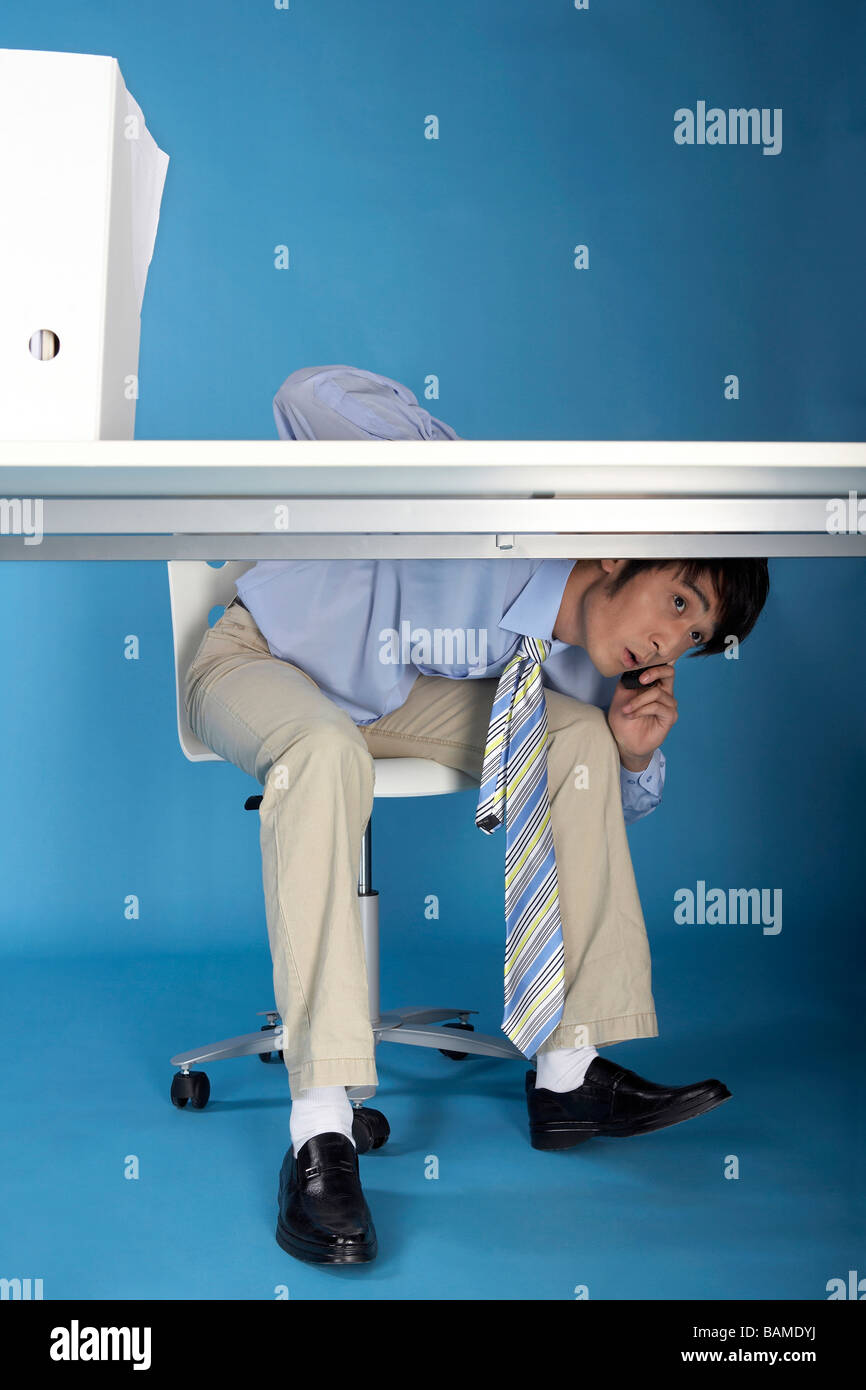 Person hiding under desk hi-res stock photography and images - Alamy
