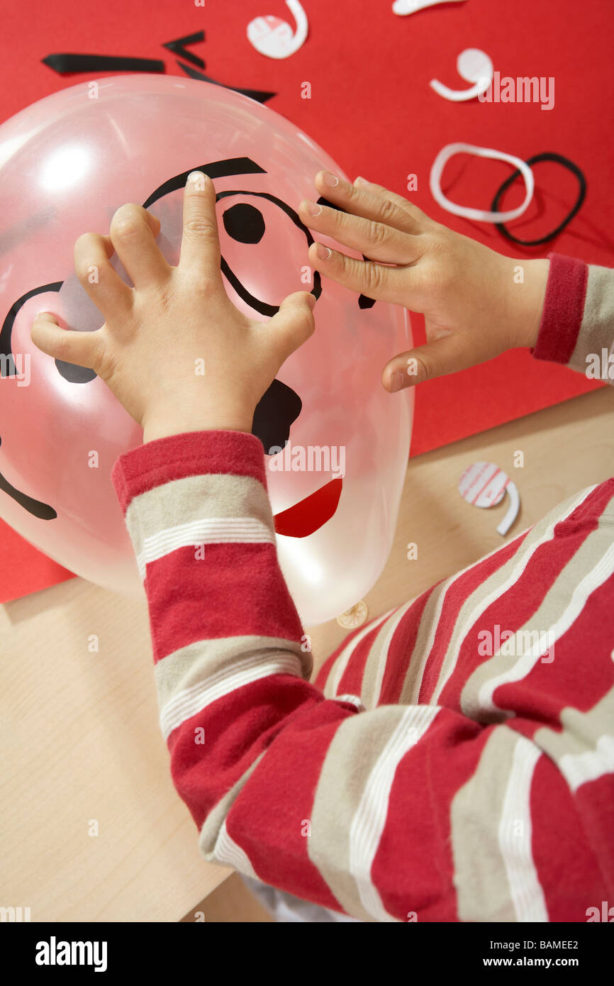 Child Decorating A Balloon Like A Face Stock Photo - Alamy