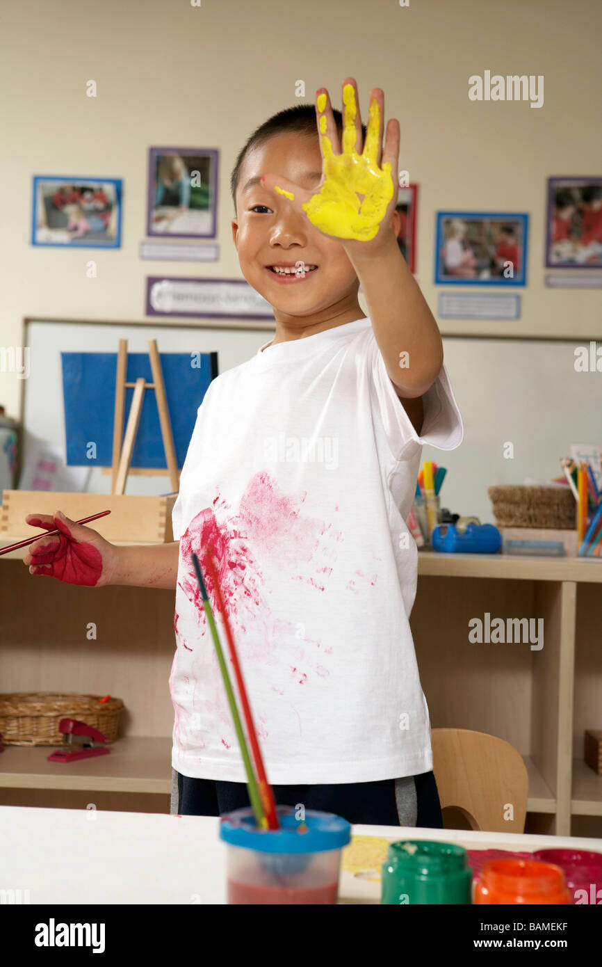 Boy Holding Up Yellow Painted Hand Stock Photo - Alamy