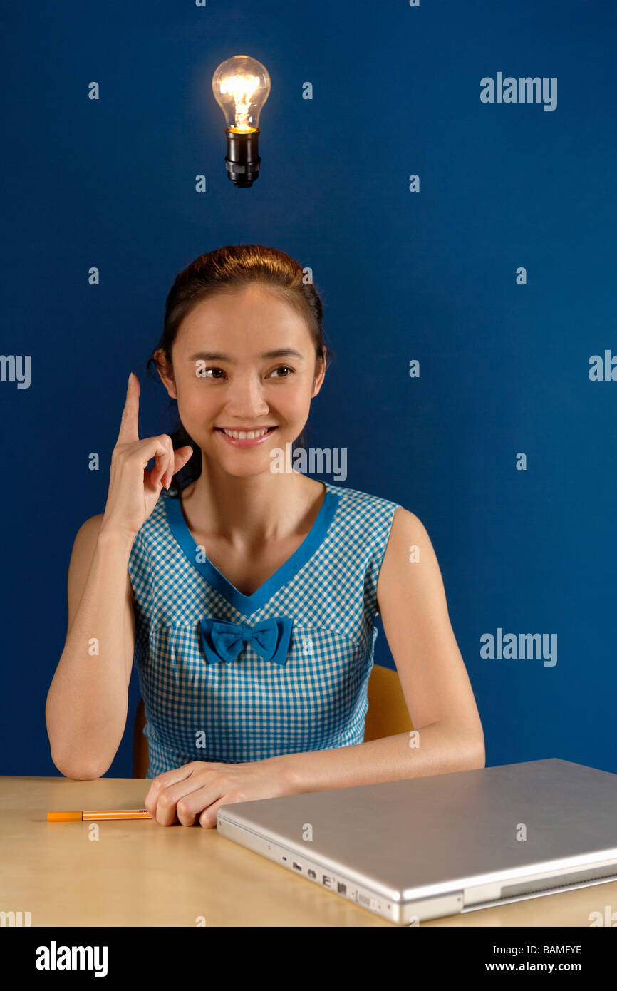 Young Woman Pointing Upwards With A Lightbulb Above Her Head Stock ...