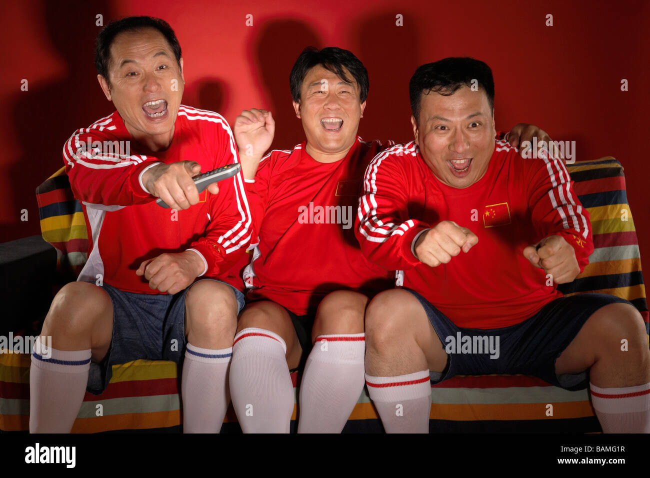 Fans Sitting On A Couch Cheering At The Television Stock Photo - Alamy