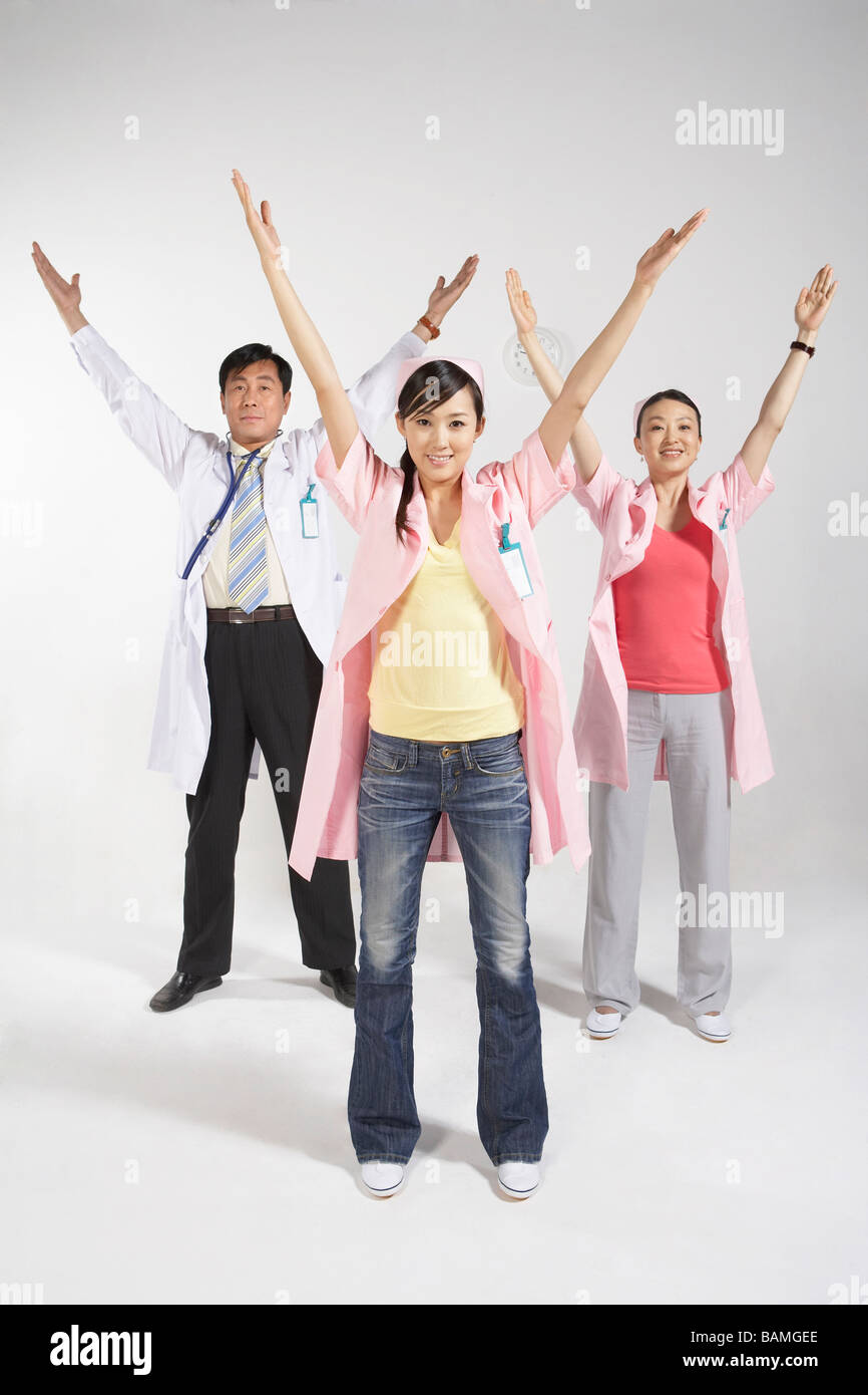 Nurses And Doctor Stretching With Arms Raised Stock Photo - Alamy