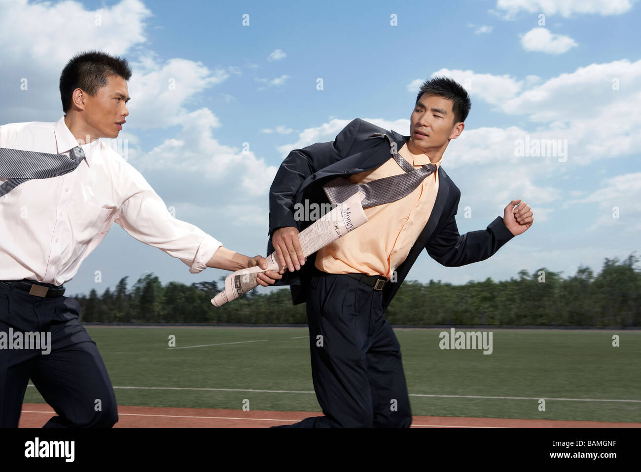 Businessmen Running, Passing A Folded Newspaper Stock Photo - Alamy