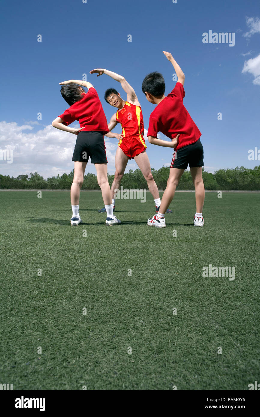 Athletes Stretching In A Field Stock Photo - Alamy