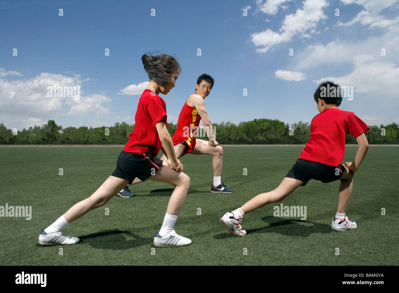 Athletes Stretching In A Field Stock Photo - Alamy