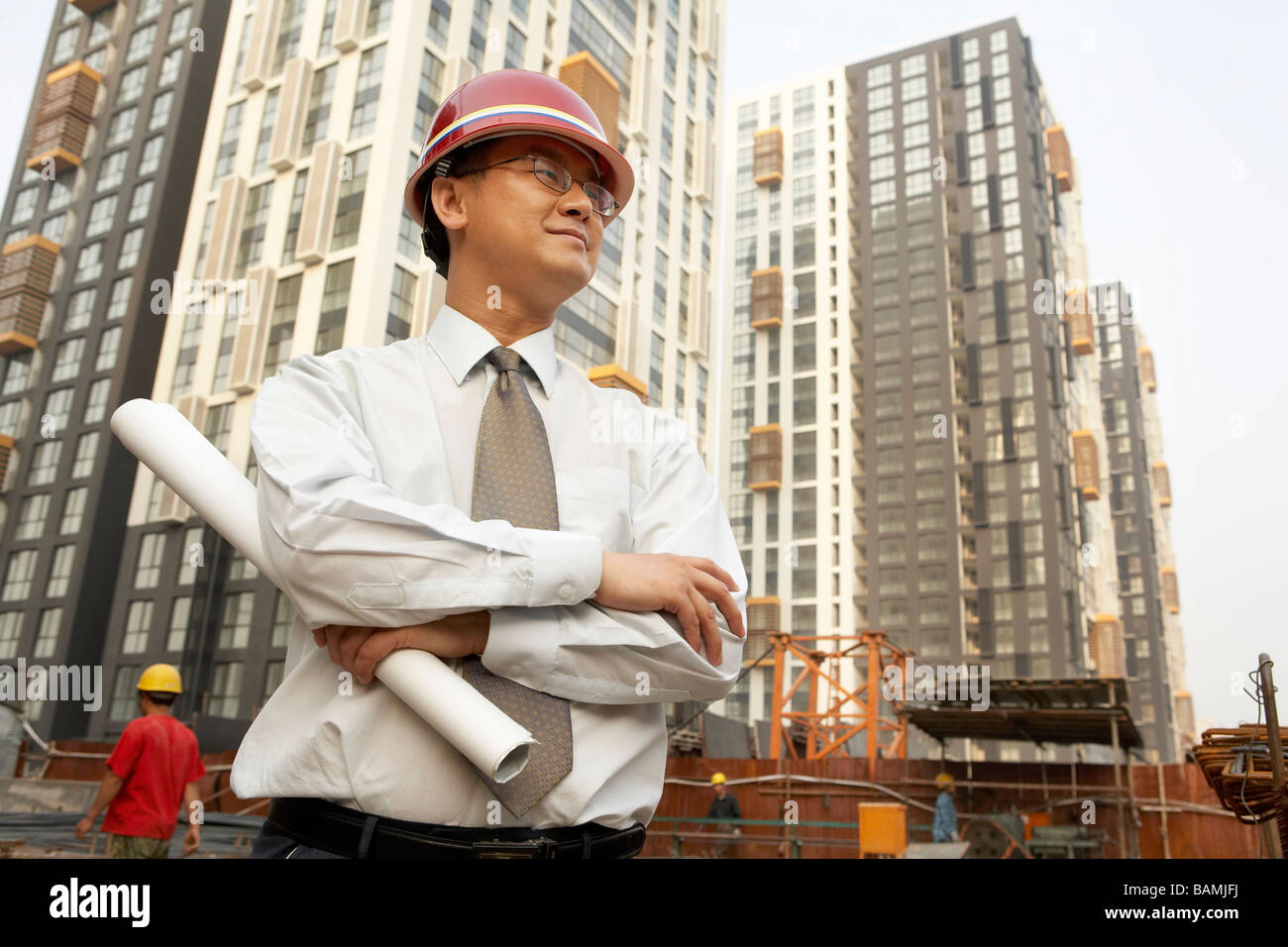 Construction Contractor Holding Building Plans, Looking Into Distance ...