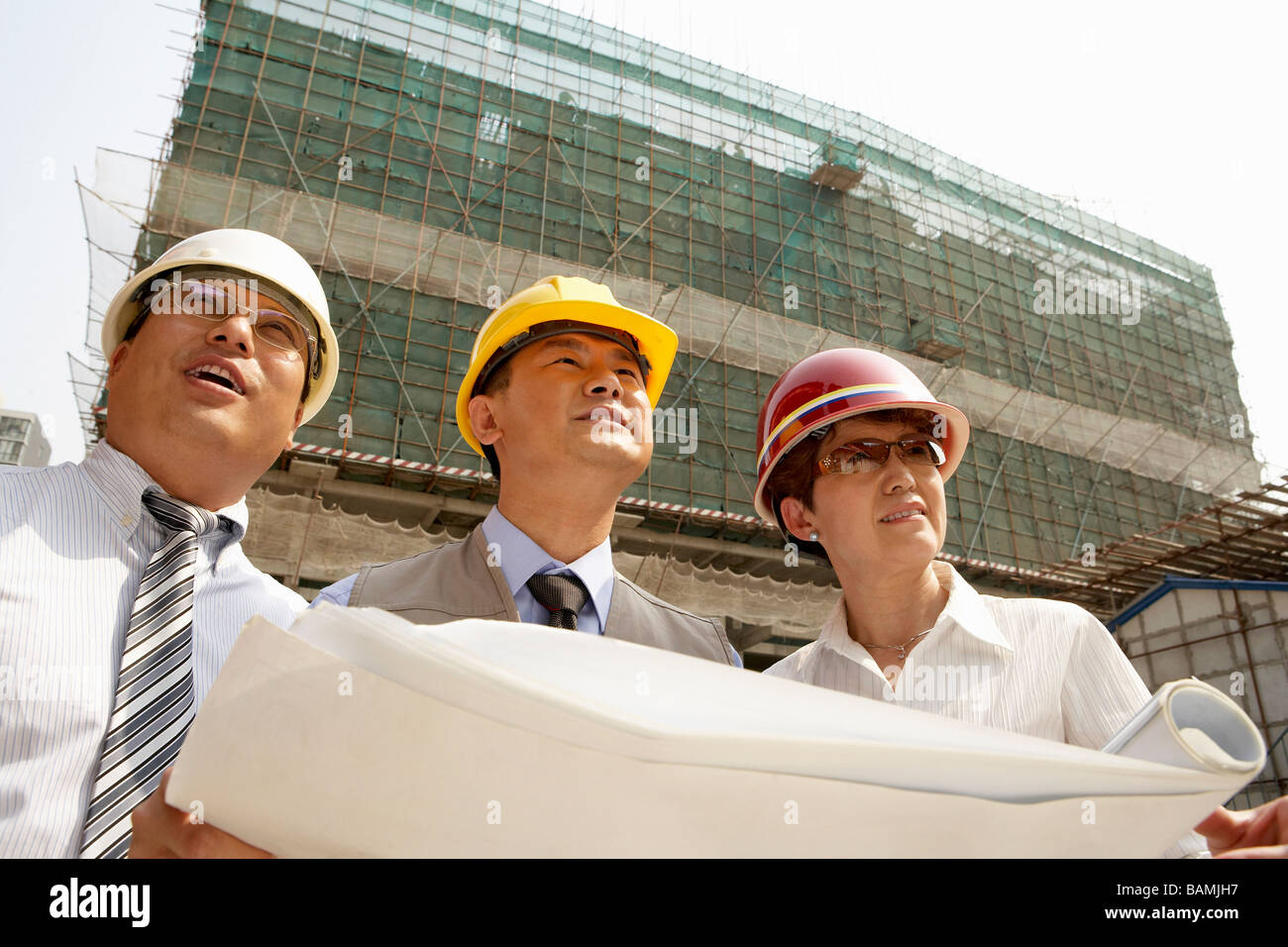 Construction Contractors Holding Building Plans, Looking Into Distance ...