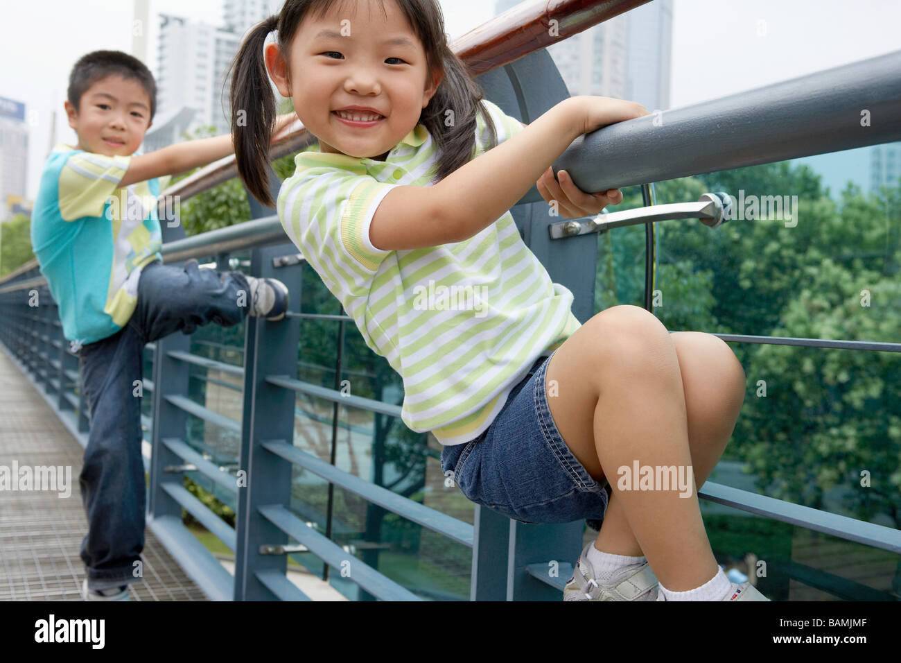 Young Boy And Young Girl Climbing A Bridge In The Park Stock Photo - Alamy