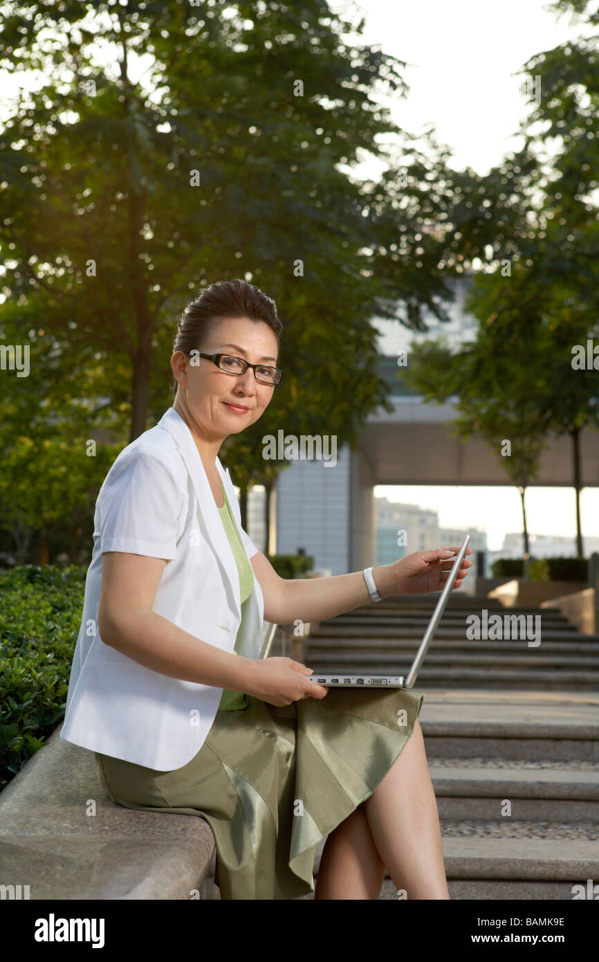 Businesswomen Sitting Using Laptop In Park Stock Photo - Alamy Businesswomen Sitting Using Laptop In Park Stock Photo - Alamy