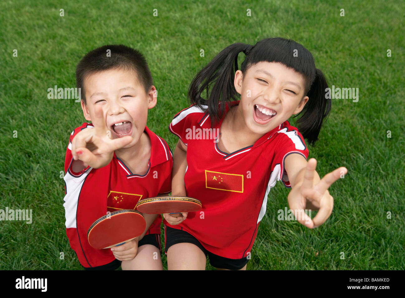 Children Holding Table Tennis Rackets And Making Peace Signs Stock ...