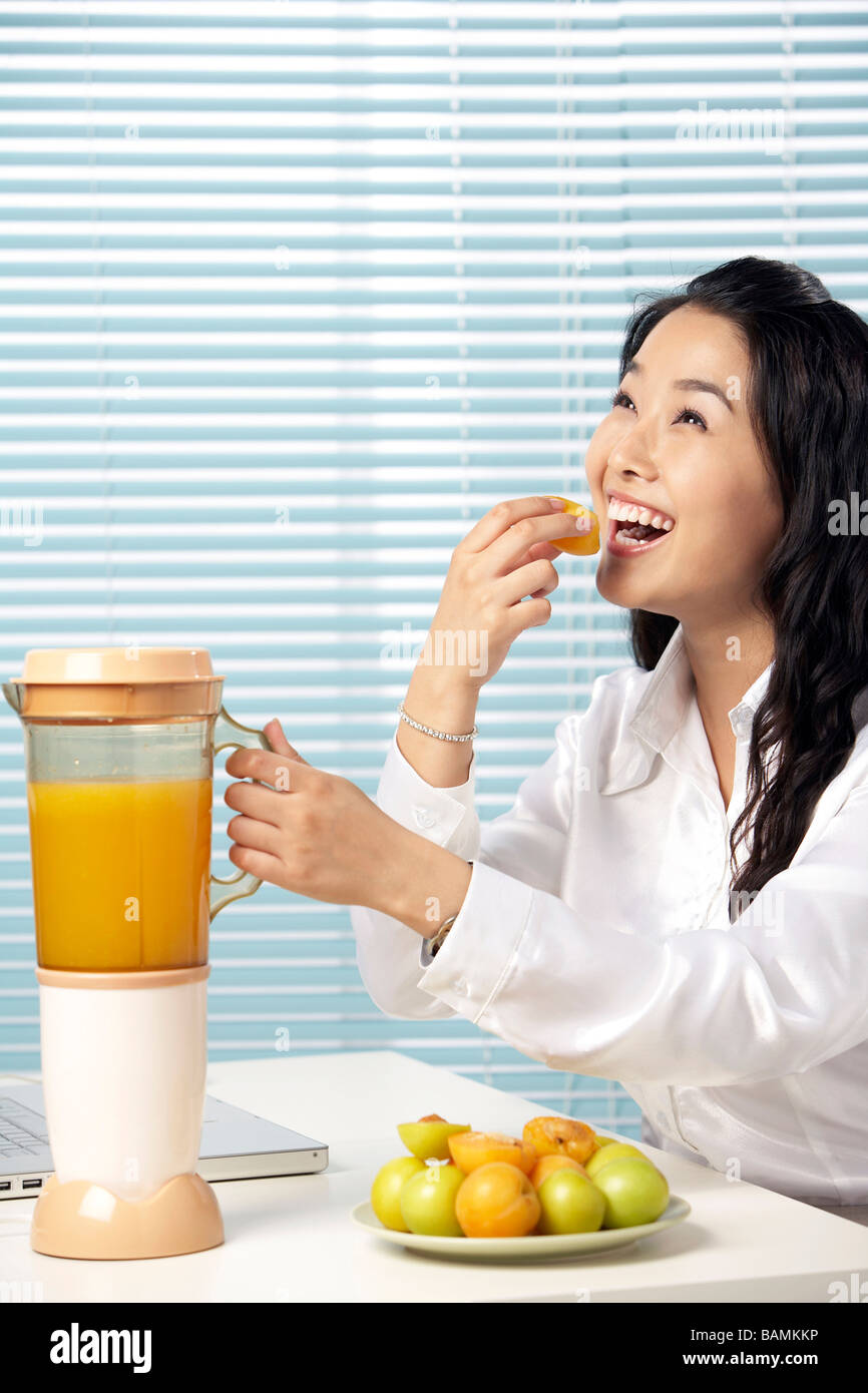 Young Woman Making Fruit Juice With A Blender Stock Photo - Alamy