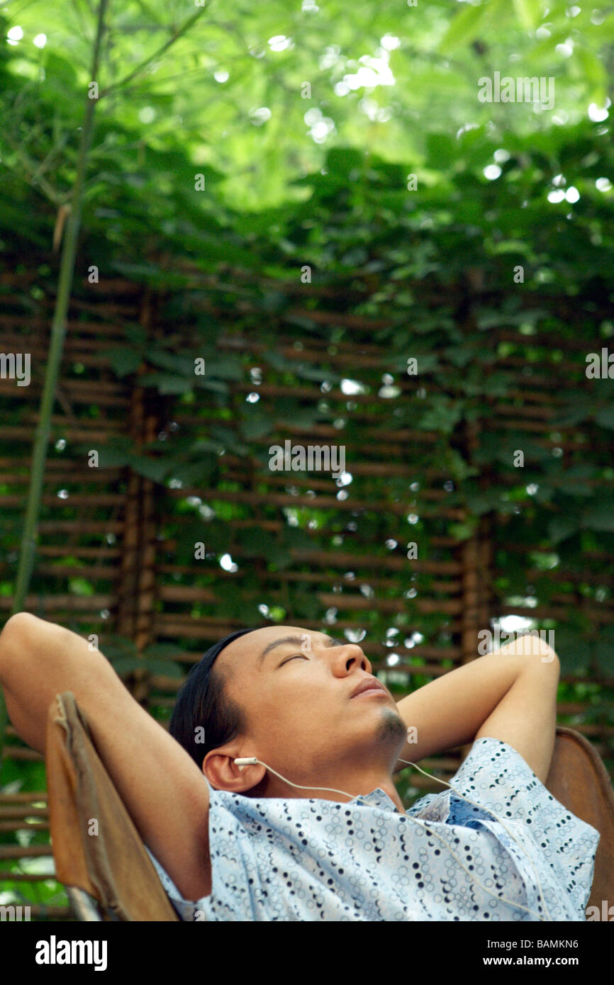 Man Sitting Relaxed In Chair, Listening To Mp3 Player Stock Photo - Alamy