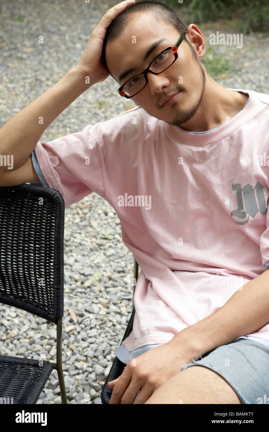 Young Man Sitting Down Leaning On Chair Looking At Camera Stock Photo ...