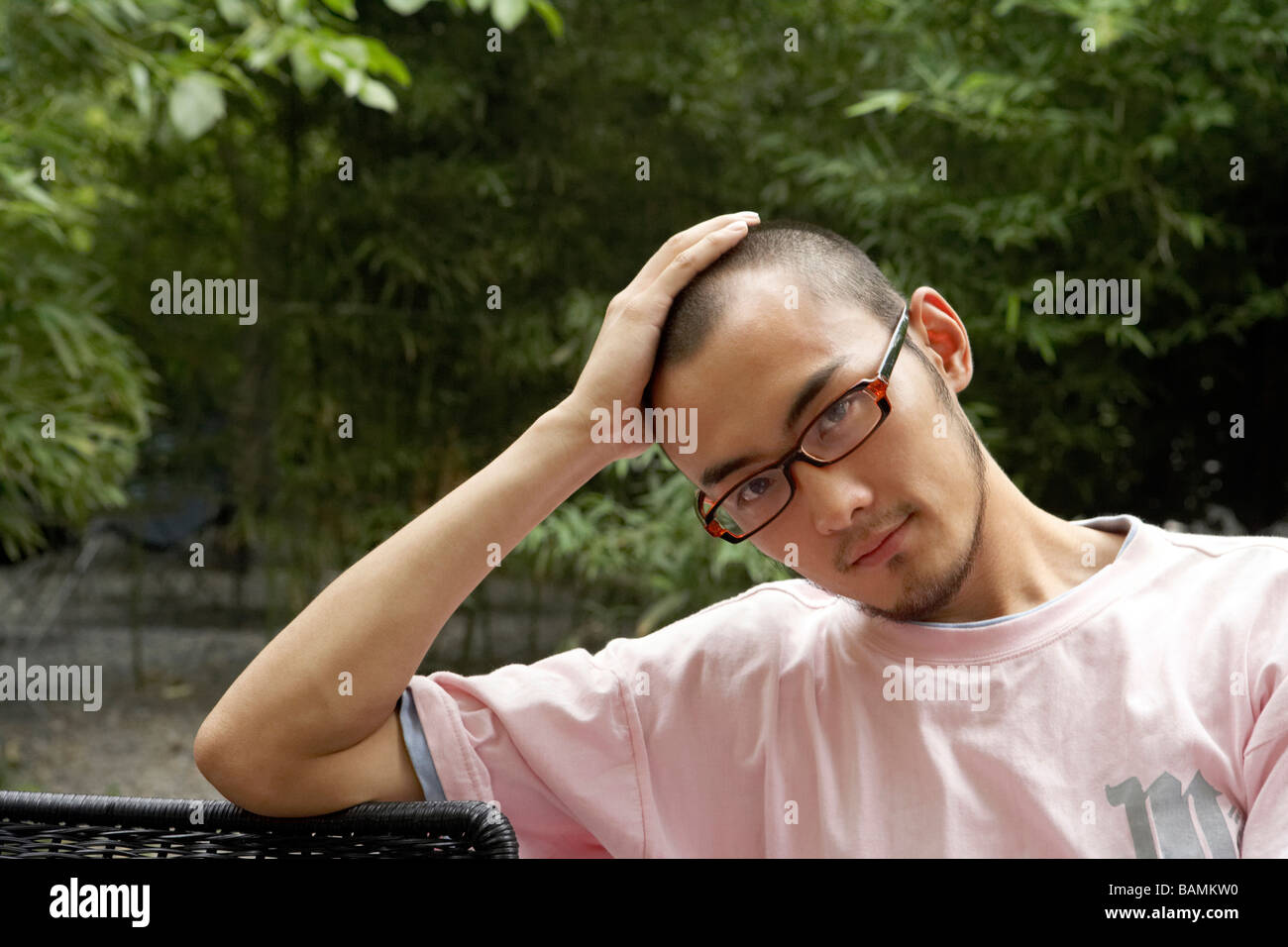 Young Man Sitting Down Leaning On Chair Looking At Camera Stock Photo ...