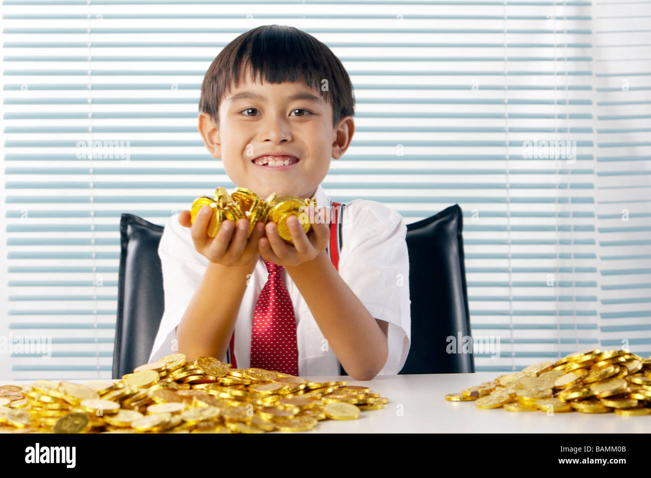 Young Boy With Gold Coins Smiling Happily Stock Photo - Alamy