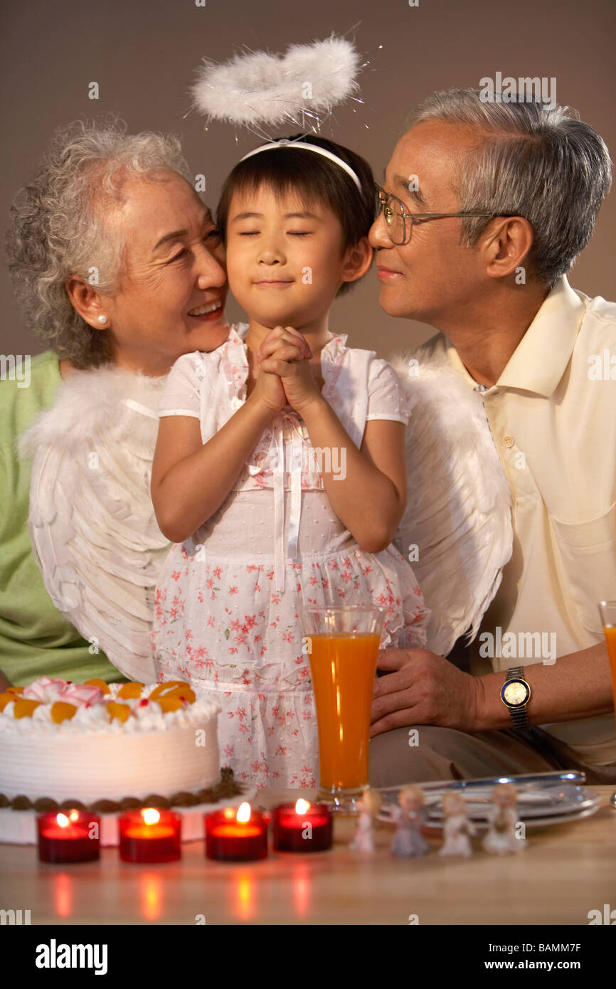 Grandparents Watch As Their Granddaughter Makes A Birthday Wish Stock ...