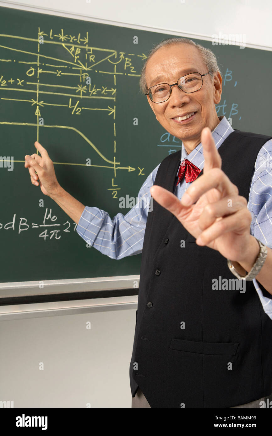 Teacher Pointing To Blackboard Stock Photo - Alamy