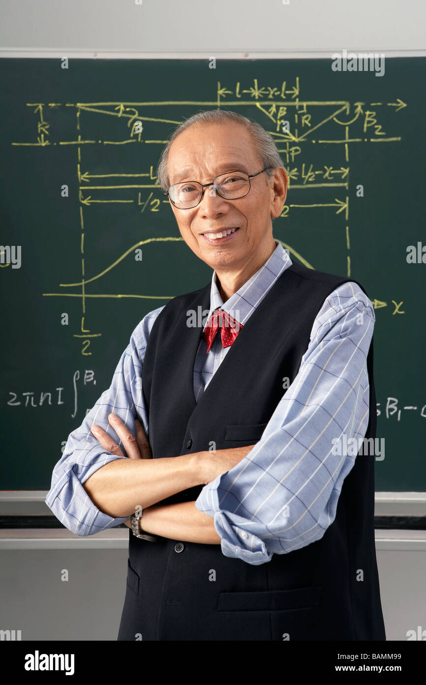 Teacher Standing In Front Of Blackboard Stock Photo - Alamy
