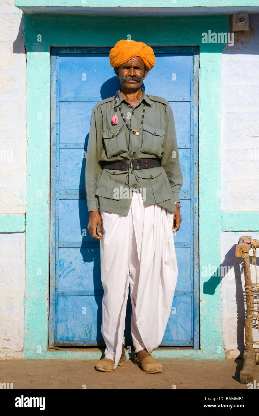 Man standing outside a colourful painted house near Osian, Rajasthan ...
