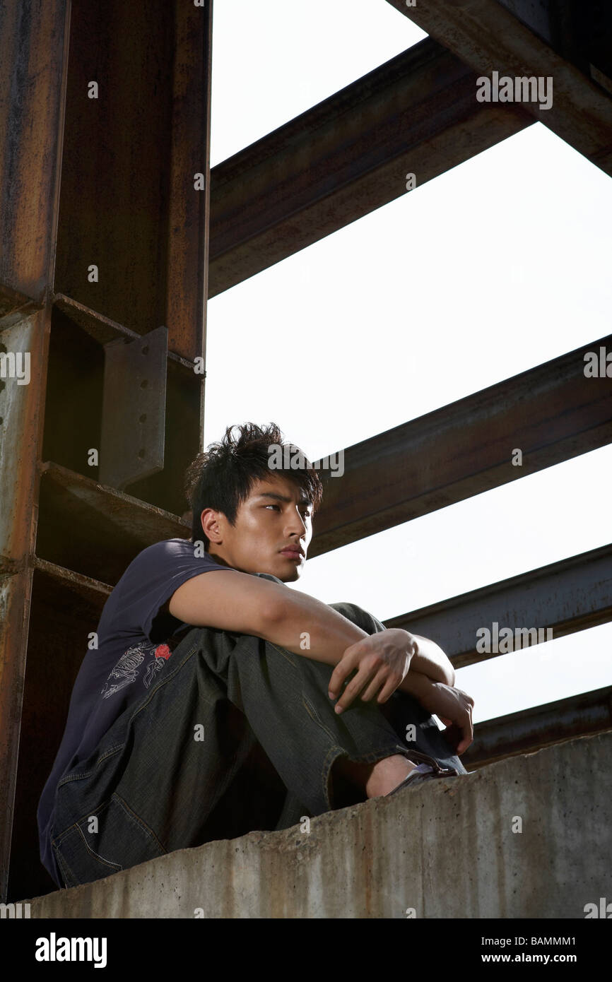 Young Man Sitting On A Beam In A Construction Site Stock Photo - Alamy