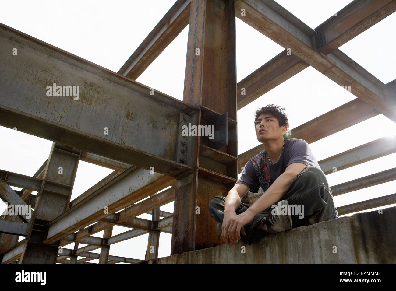 Young Man Sitting On A Beam In A Construction Site Stock Photo - Alamy