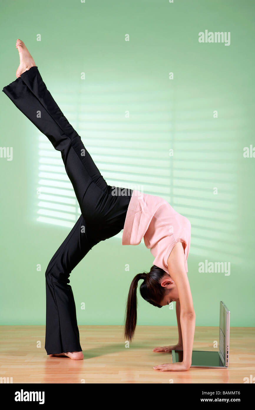 Woman Bent Backwards Looking At A Laptop Computer Stock Photo - Alamy