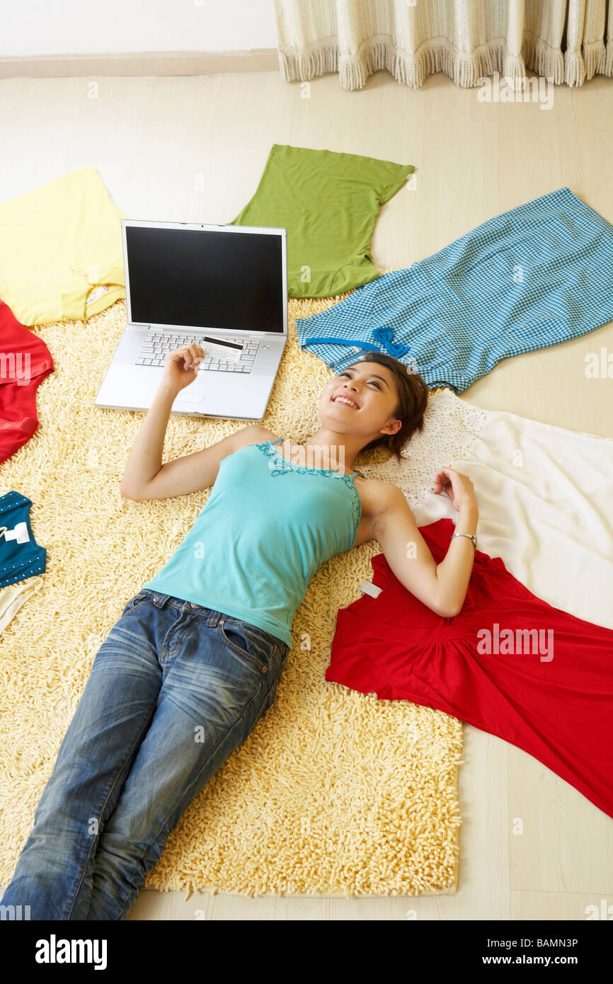 Young Woman Laying On The Floor With Clothes Stock Photo - Alamy