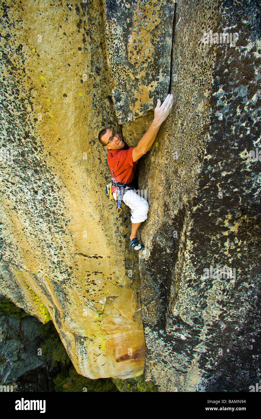 Climber reaching for his next hold on a steep cliff in Sequoia National ...