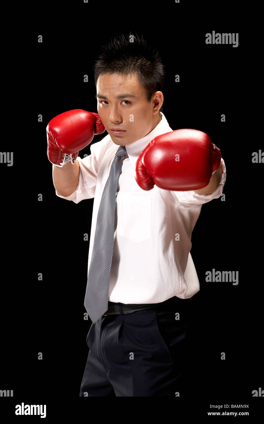 Businessman Wearing Boxing Gloves And Punching Stock Photo - Alamy