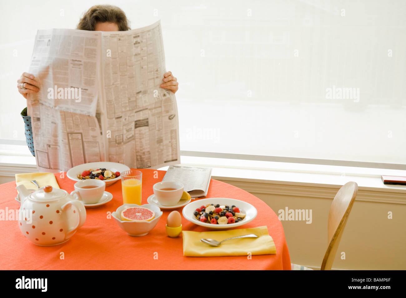 Woman at home having breakfast and reading newspaper Stock Photo - Alamy