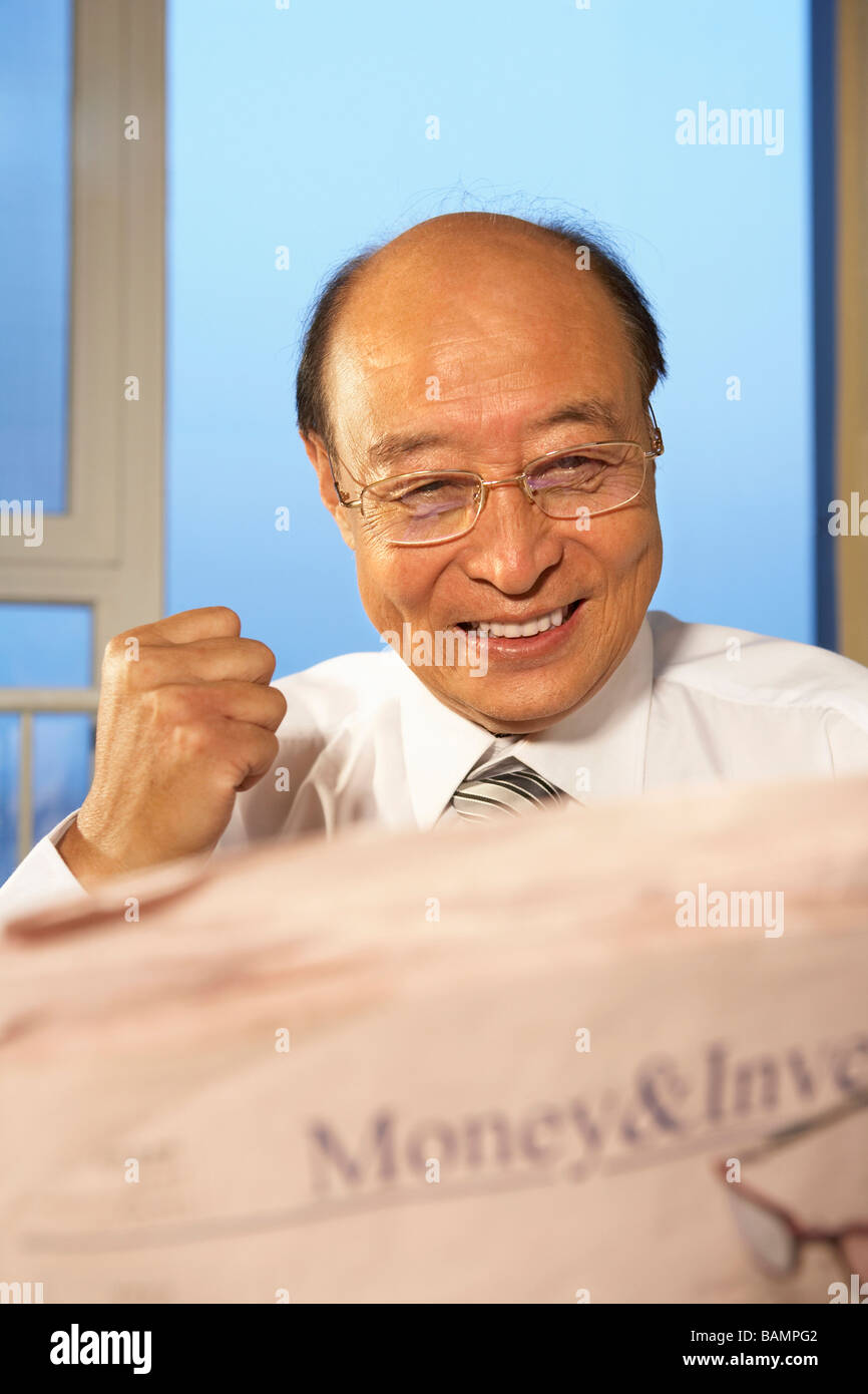 Businessman Reading Newspaper Smiling Stock Photo Alamy