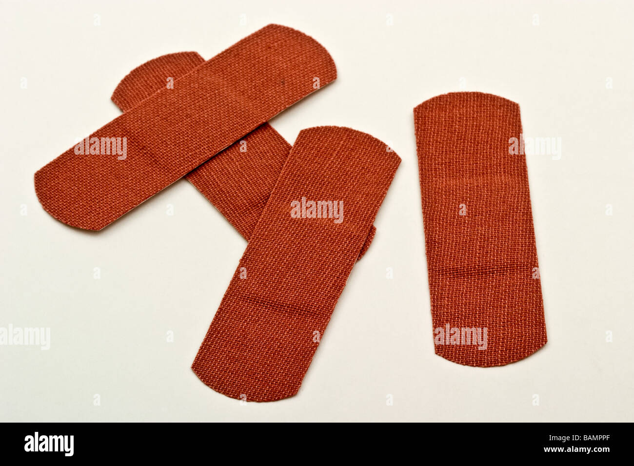 A pile of 4 extra strength fabric band aids Stock Photo - Alamy