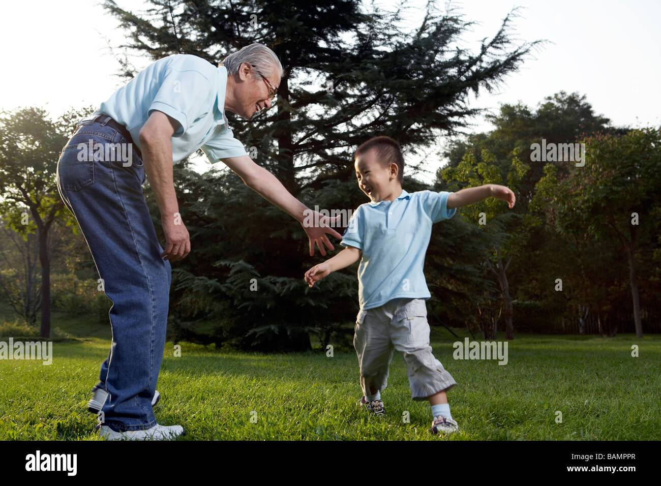 Grandfather And His Grandson Playing Together In Park Stock Photo - Alamy